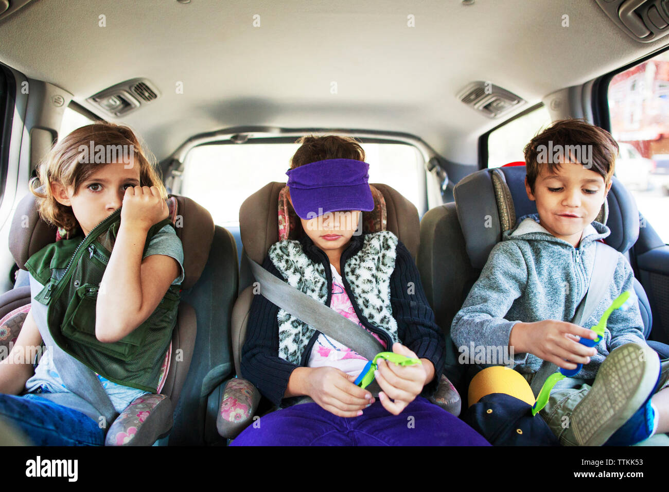 Close-up of siblings sitting in car Stock Photo - Alamy