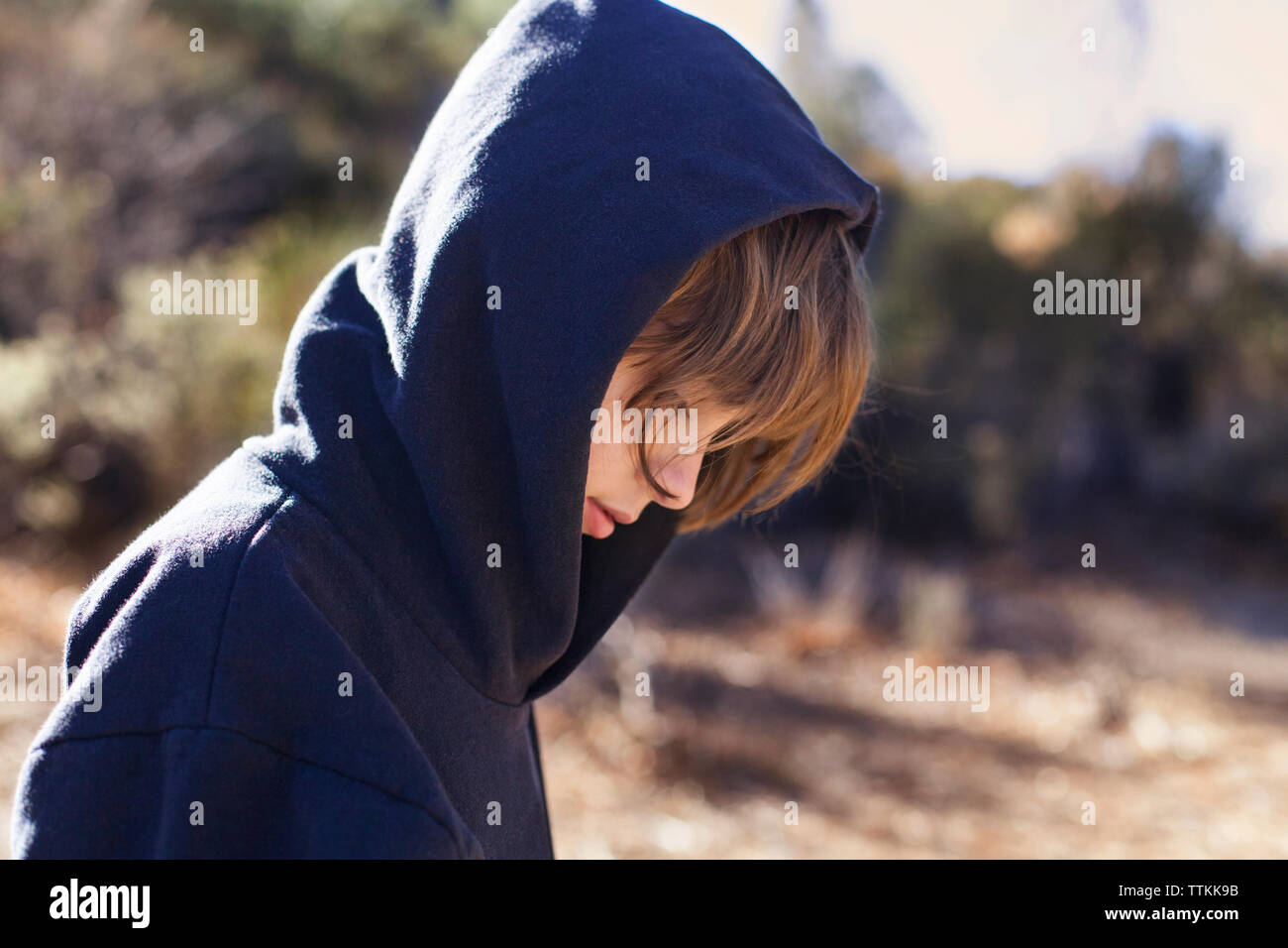 Side view of thoughtful girl wearing hood outdoors Stock Photo - Alamy