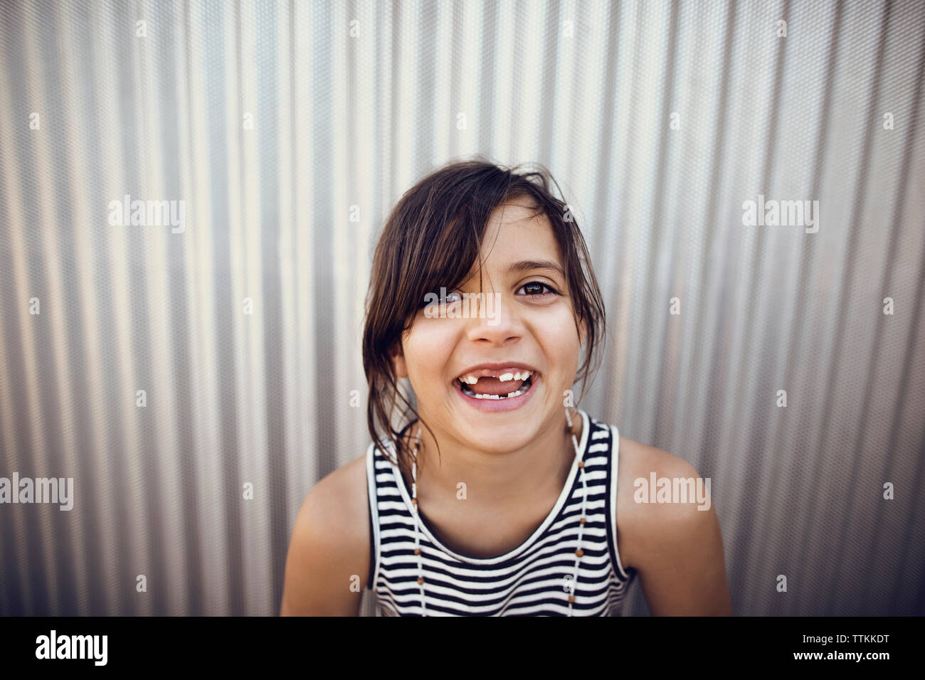Portrait of happy girl standing against shutter Stock Photo - Alamy
