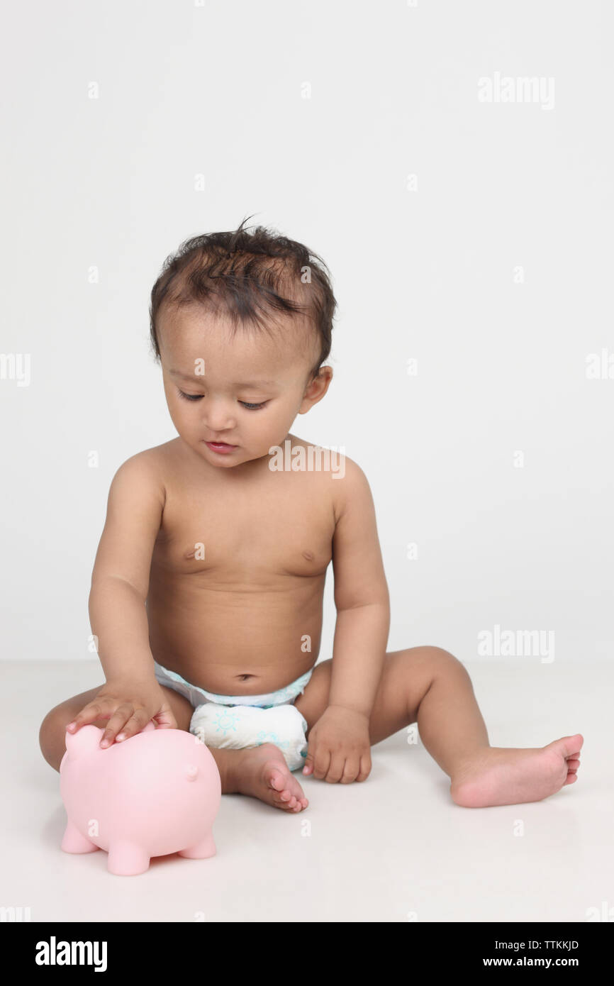 Baby boy playing with a piggy bank Stock Photo - Alamy