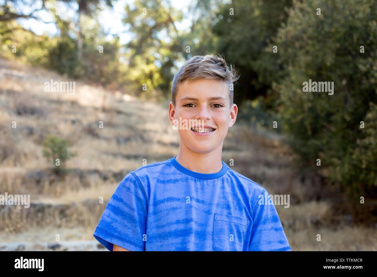 Smiling portrait of a boy with braces out in nature Stock Photo - Alamy