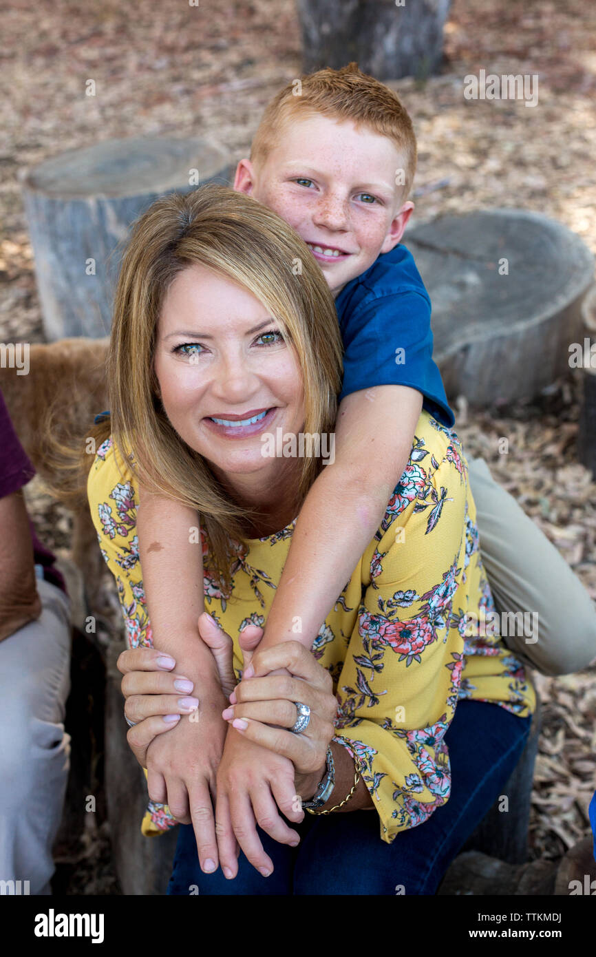 Young boy wraps arms around back of mother for a portrait Stock Photo ...