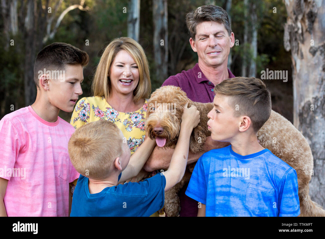 Labradoodle gets all the attention from family of five Stock Photo - Alamy