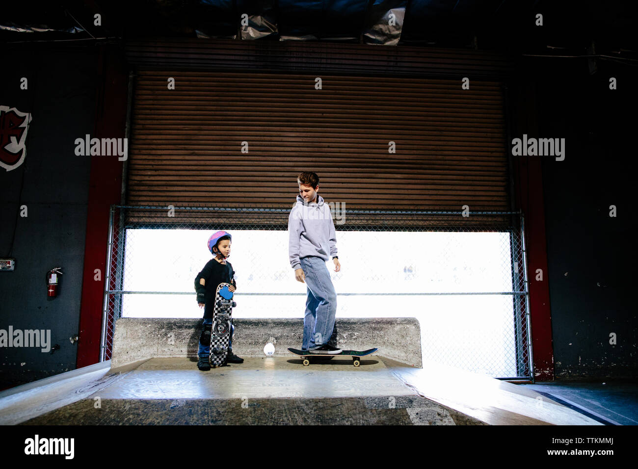 Skateboard instructor looks back at child during lesson Stock Photo - Alamy