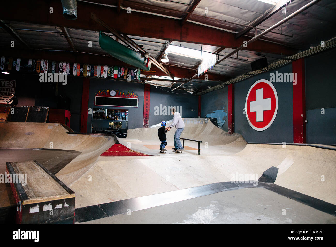 Wide shot of skateboard instructor holding hands with student Stock ...
