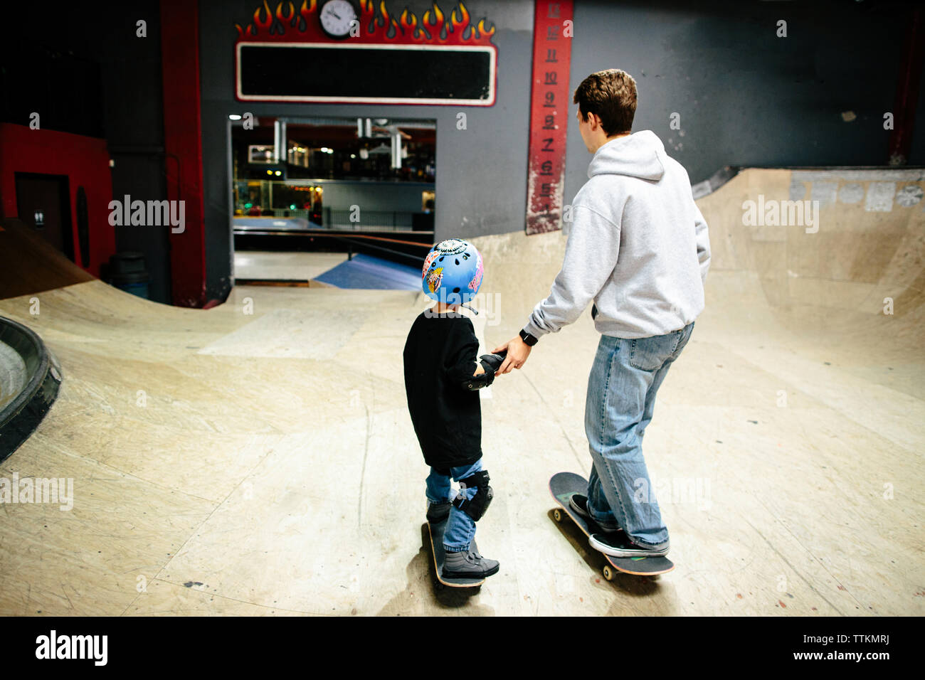 Back of student and teacher skateboarding Stock Photo - Alamy