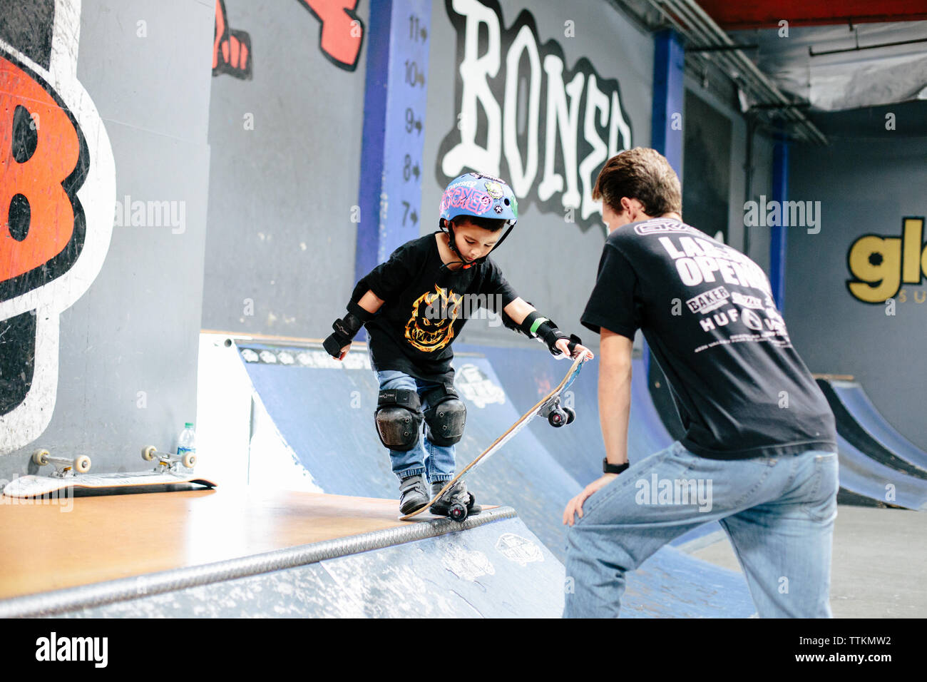 Young boy gets skateboard ready to drop in on a ramp Stock Photo - Alamy
