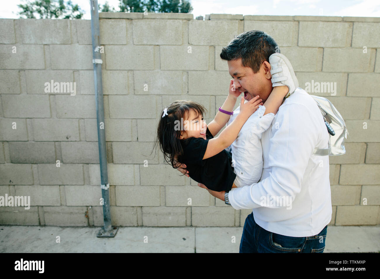 Father dips toddler daughter playfully Stock Photo - Alamy