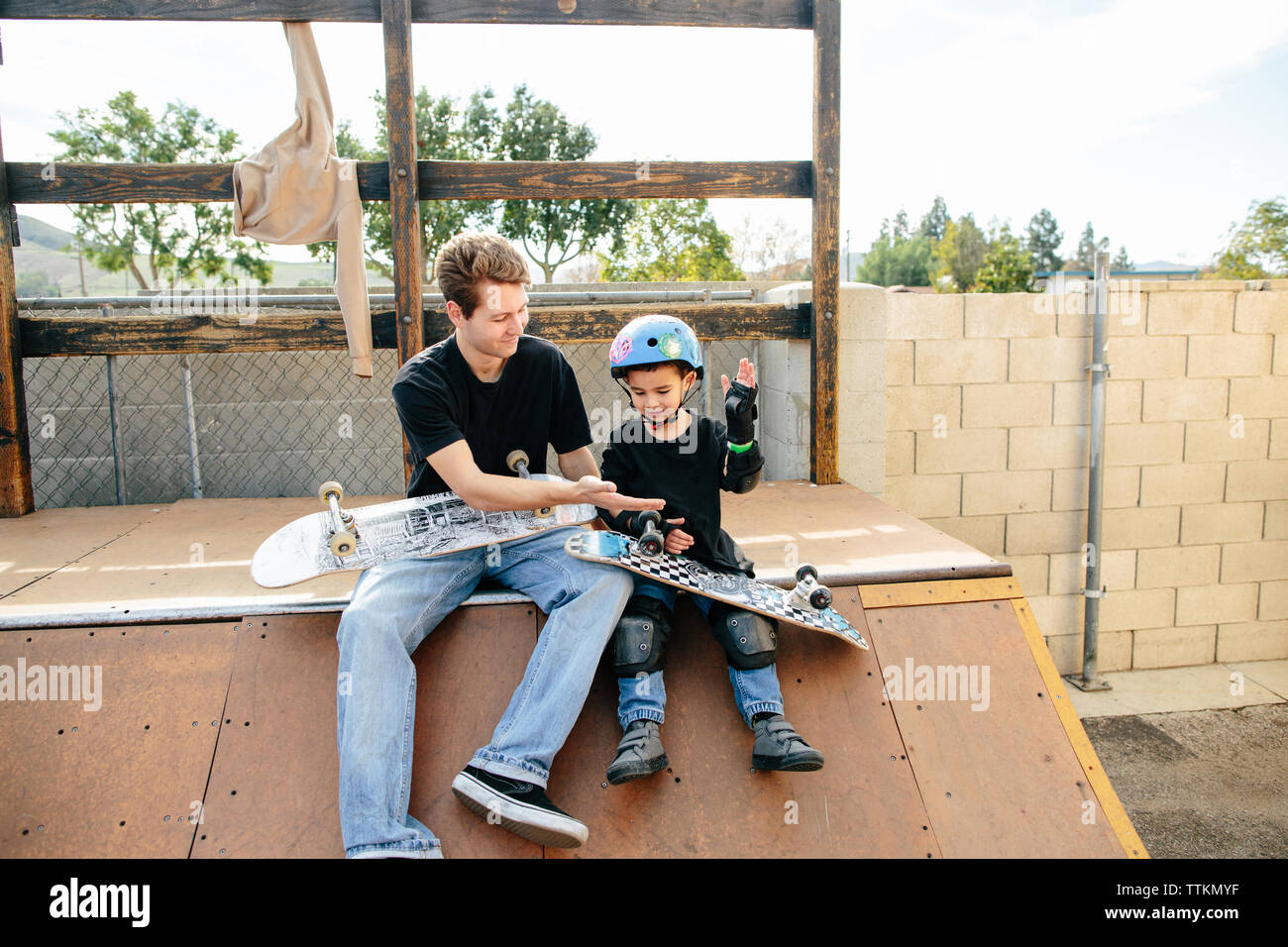 Skateboarding instructor and student high five Stock Photo - Alamy