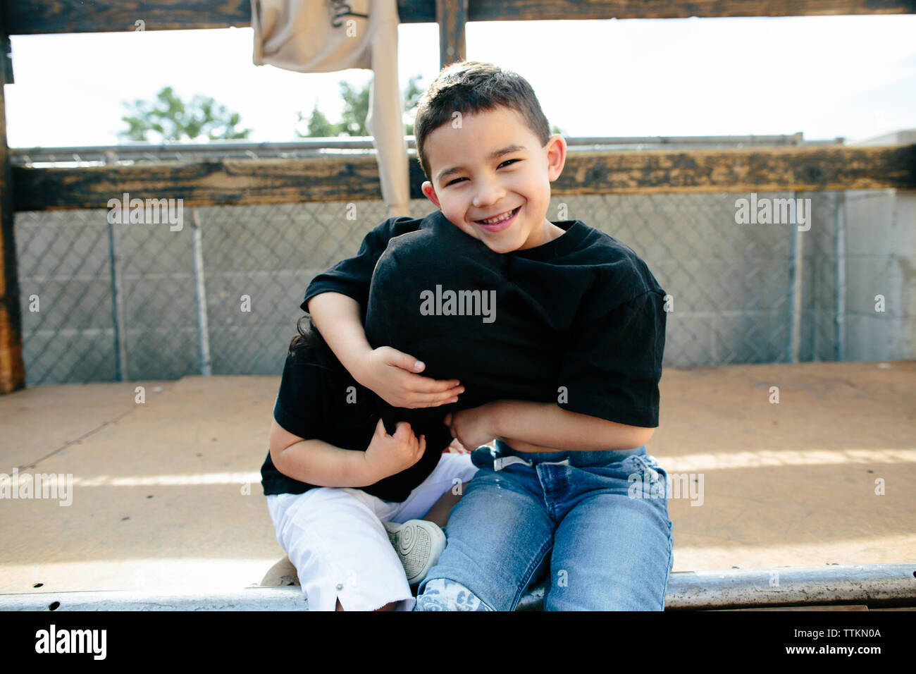 Little boy puts his shirt over little sister's head Stock Photo - Alamy