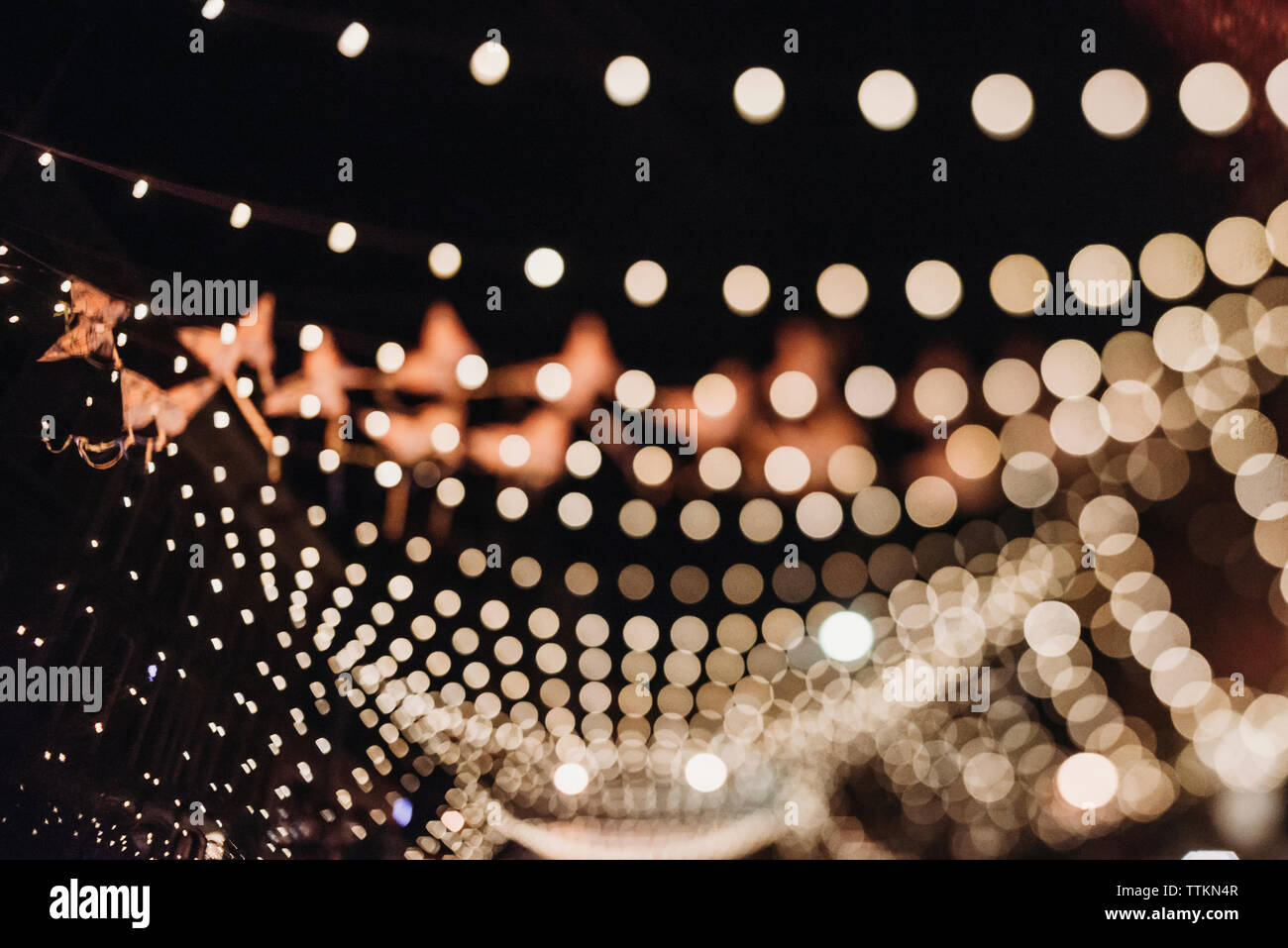 Defocused image of illuminated string lights during night Stock Photo ...