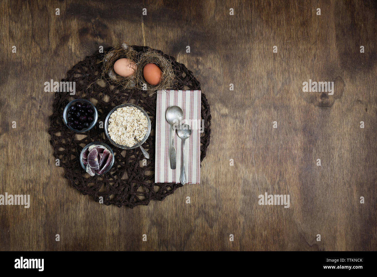 Overhead view of breakfast cereal with fruits and eggs on plate mat ...
