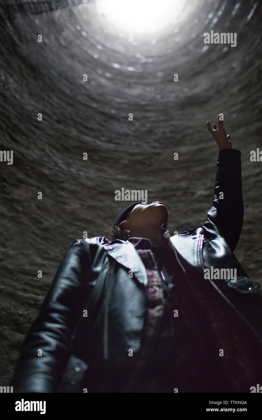 Low angle view of man standing in empty well Stock Photo - Alamy