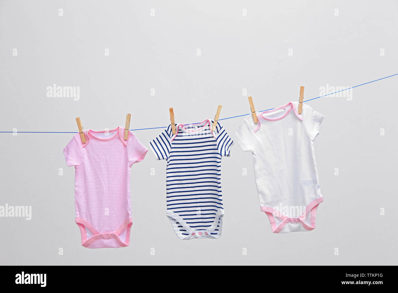 Baby clothes hanging on rope, isolated on white Stock Photo - Alamy