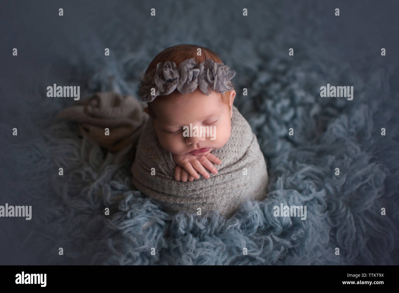Cute sleeping baby girl wrapped in blanket on rug at home Stock Photo ...