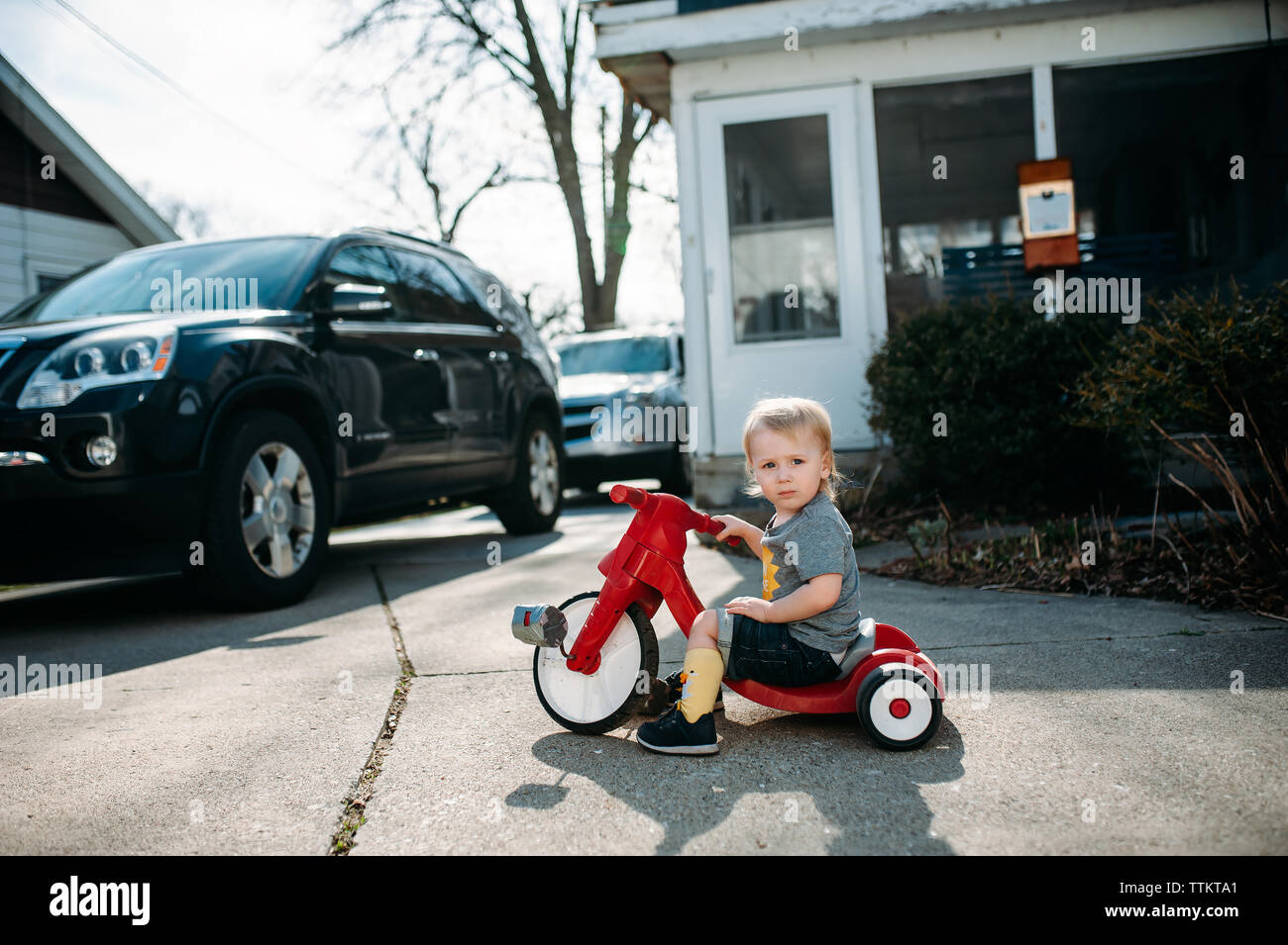 Young boy riding bike on driveway outside in summer Indiana Stock Photo ...