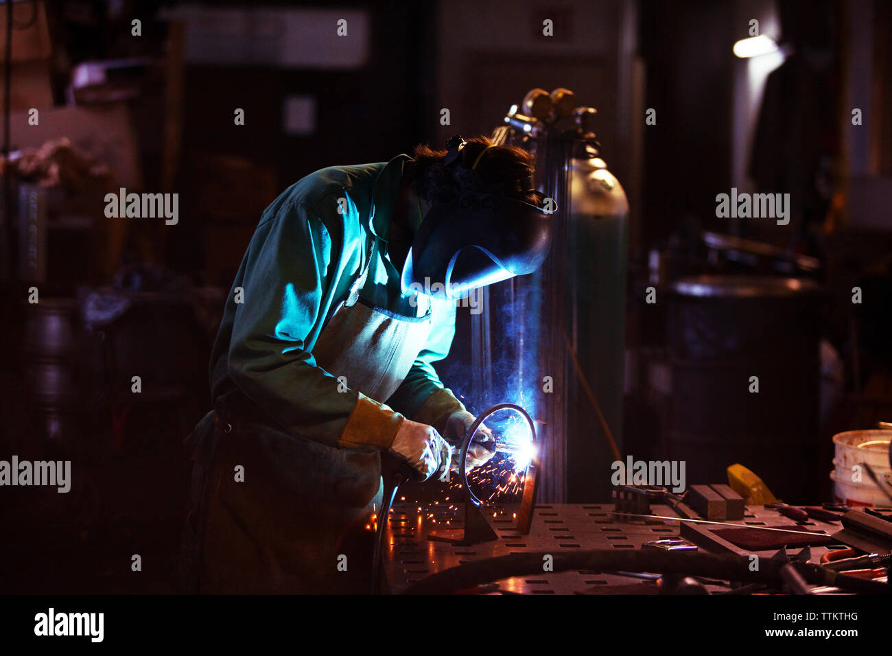 Side view of manual worker welding in workshop Stock Photo - Alamy