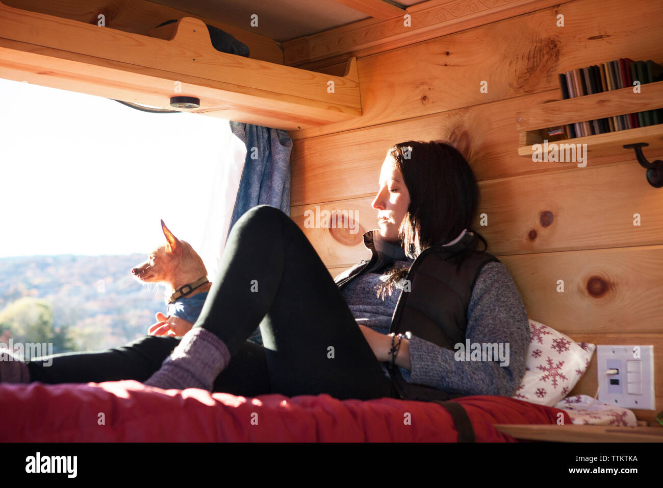Woman relaxing on bed in camper van Stock Photo - Alamy
