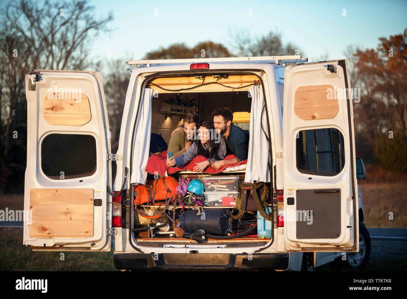 Friends talking selfie while lying on bed in camper van Stock Photo - Alamy