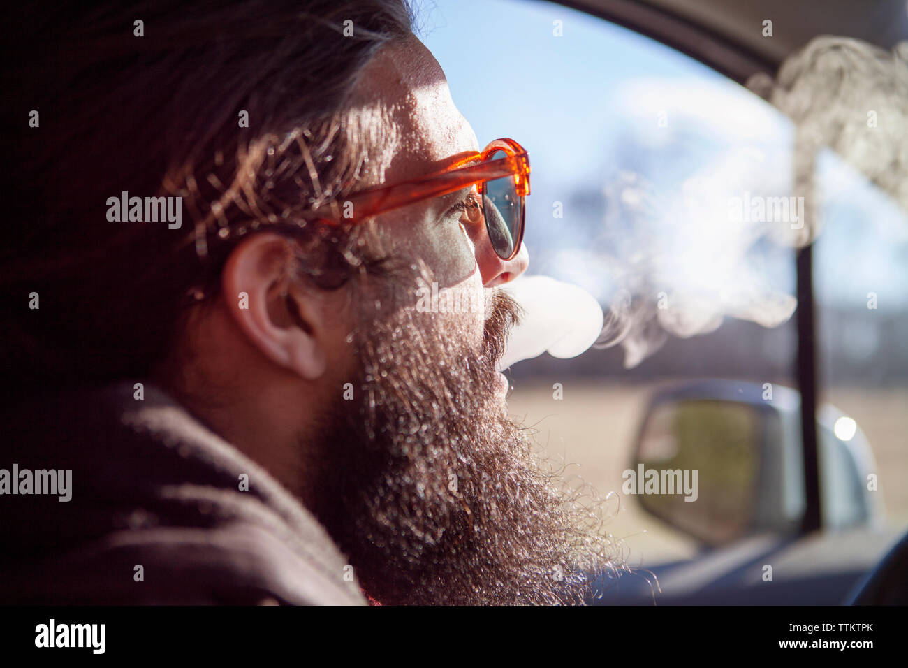 Side view of male hipster smoking in car during vacation Stock Photo ...