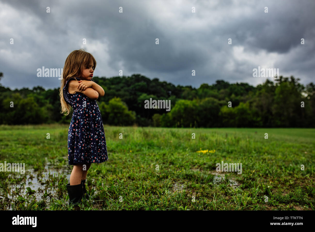 Angry wet child on a rainy day in a wet field throwing a tantrum Stock ...