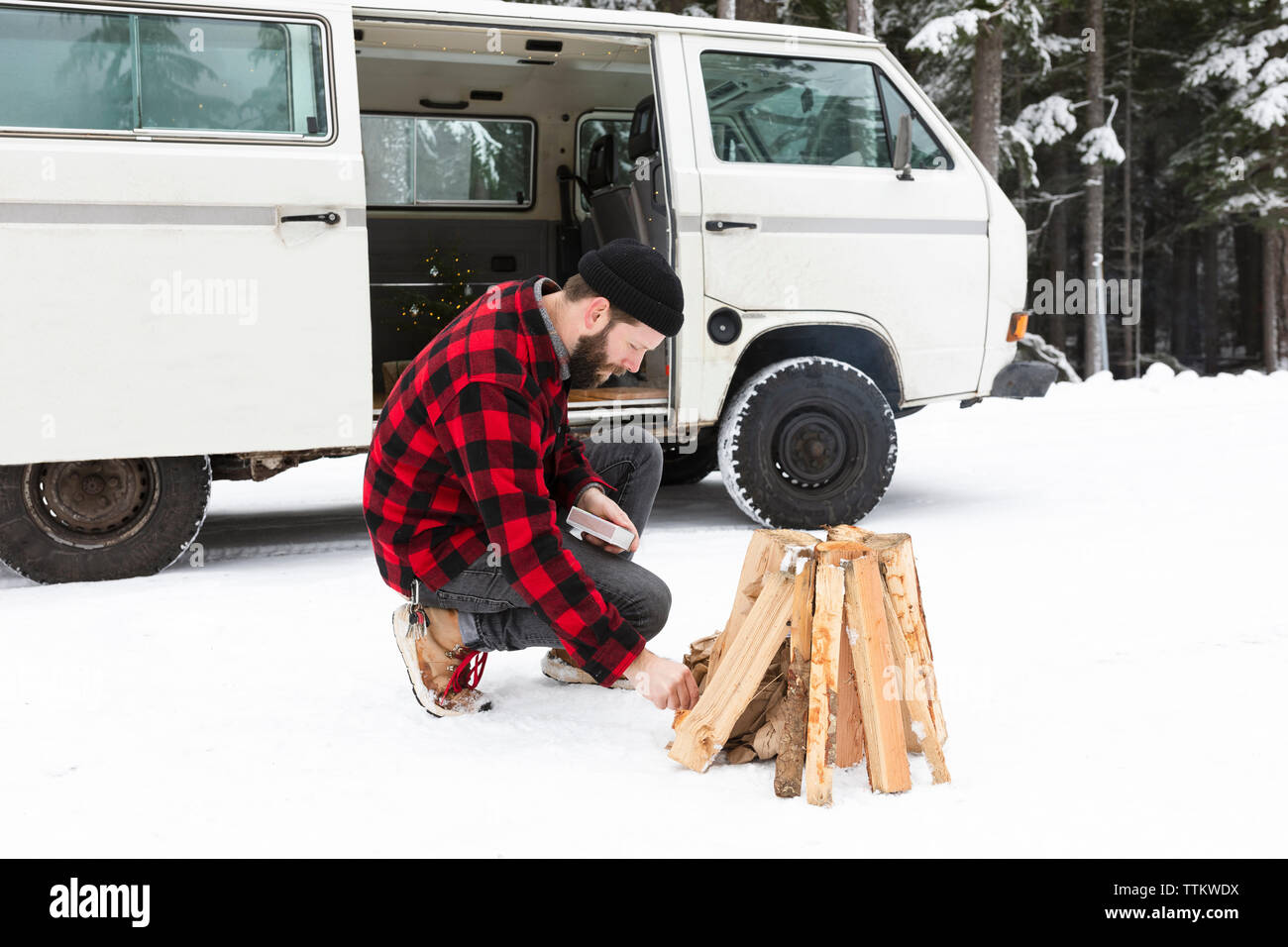 Man building fire outside his van Stock Photo - Alamy