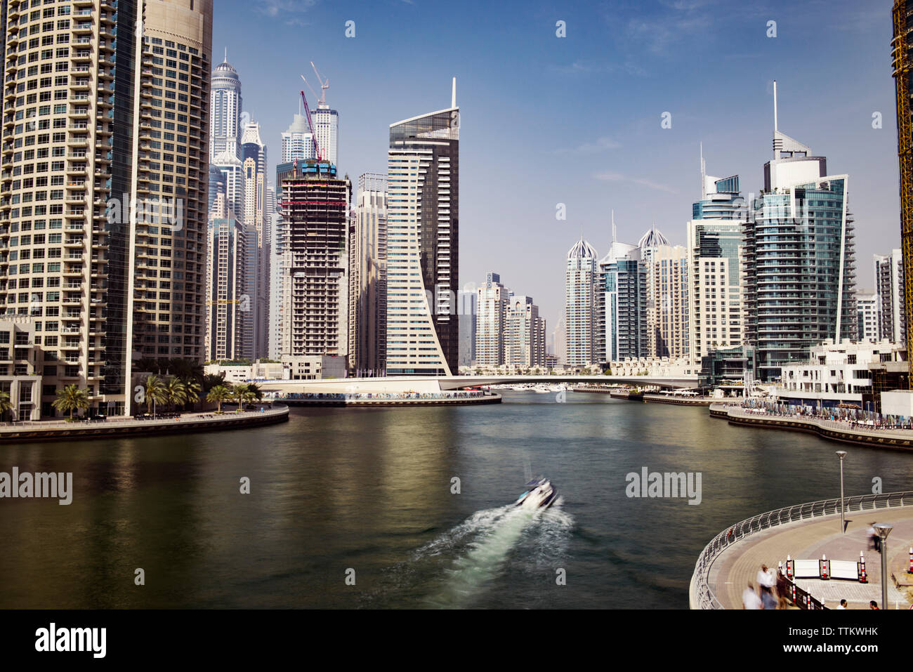Boat moving on Dubai creek amidst modern buildings against sky Stock ...