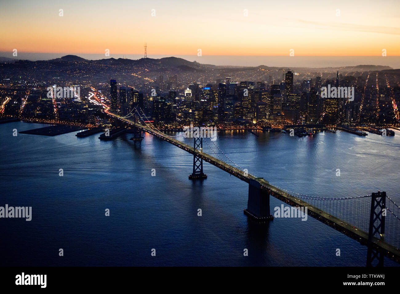 Aerial view of Bay Bridge and illuminated cityscape during sunset Stock ...