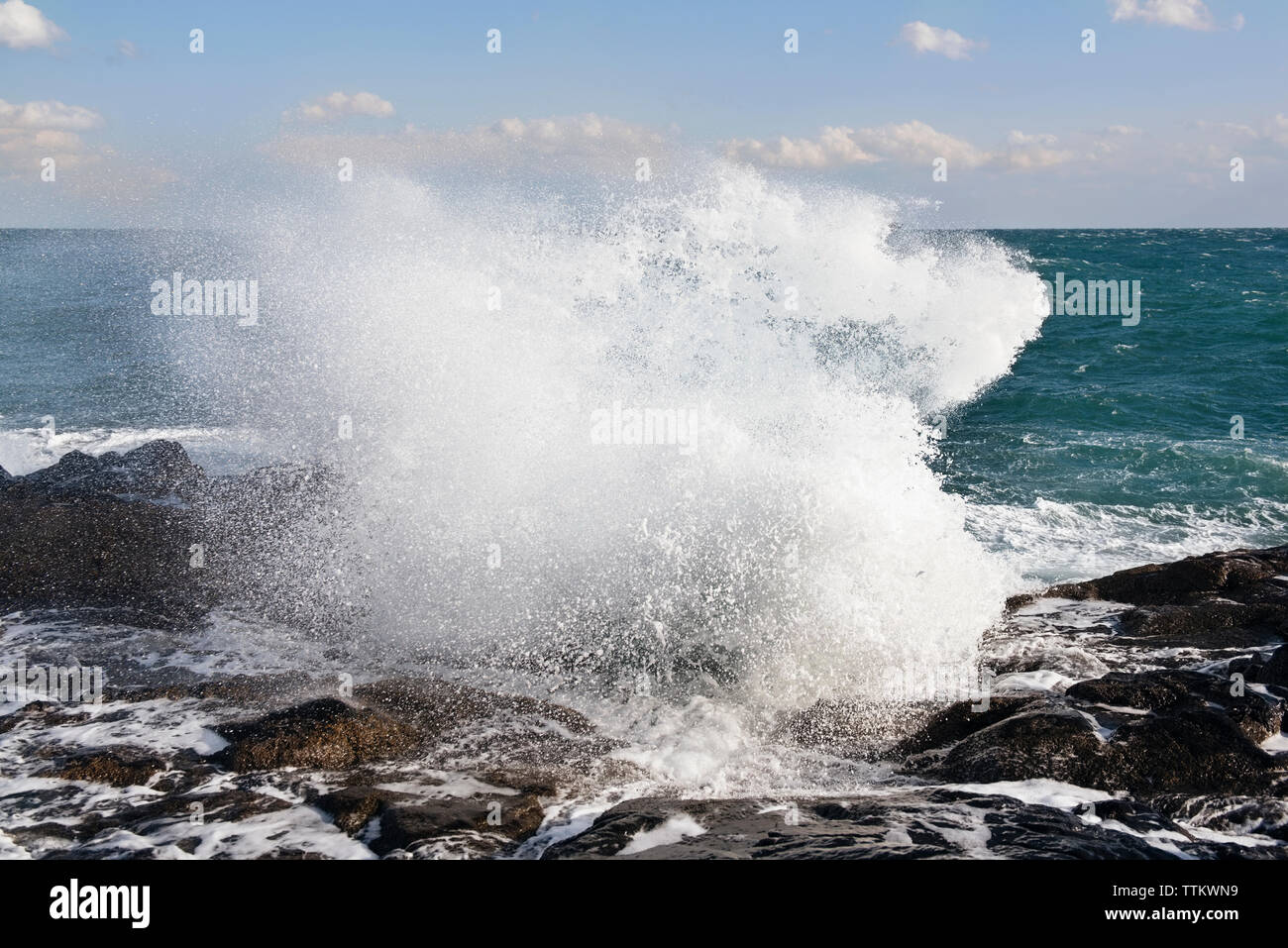 Waves crashing on rocks at beach Stock Photo - Alamy