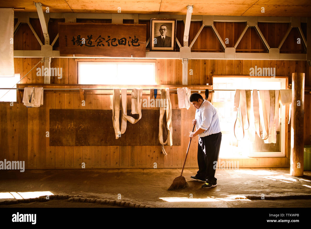 Side view of man sweeping in sumo beya Stock Photo - Alamy