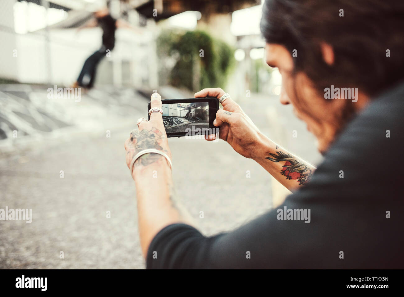Man photographing with mobile phone on city street Stock Photo - Alamy