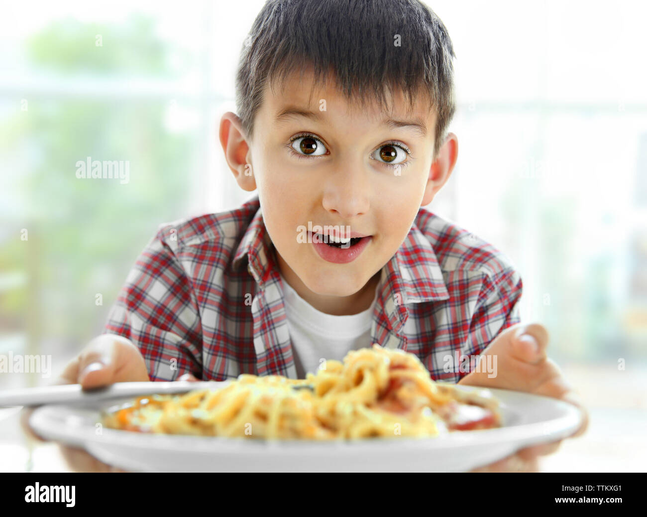 Cute boy eating spaghetti on kitchen Stock Photo - Alamy