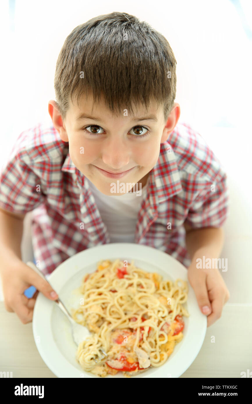 Cute boy eating spaghetti on kitchen Stock Photo - Alamy