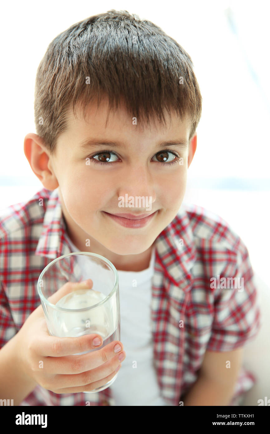 Cute boy drinking water on kitchen Stock Photo - Alamy