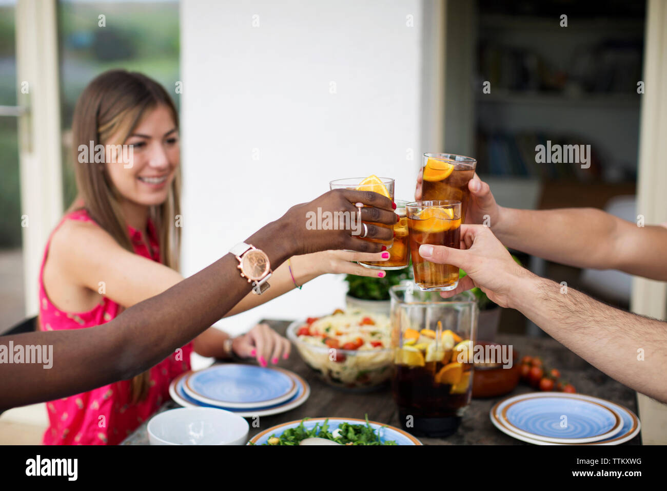 Woman toasting iced tea glasses with friends at outdoor table Stock ...