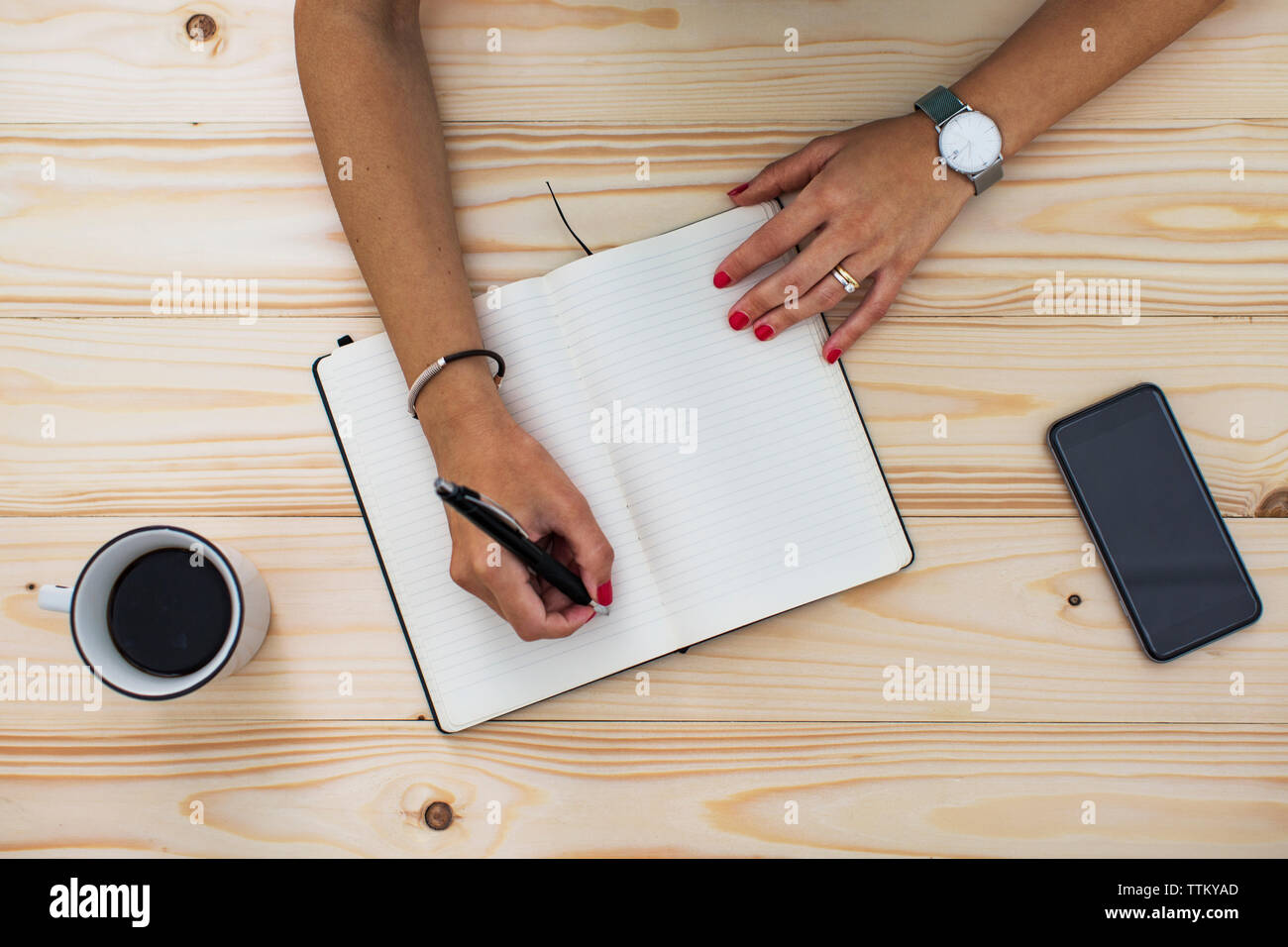 Overhead view of businesswoman writing in diary at office desk Stock ...