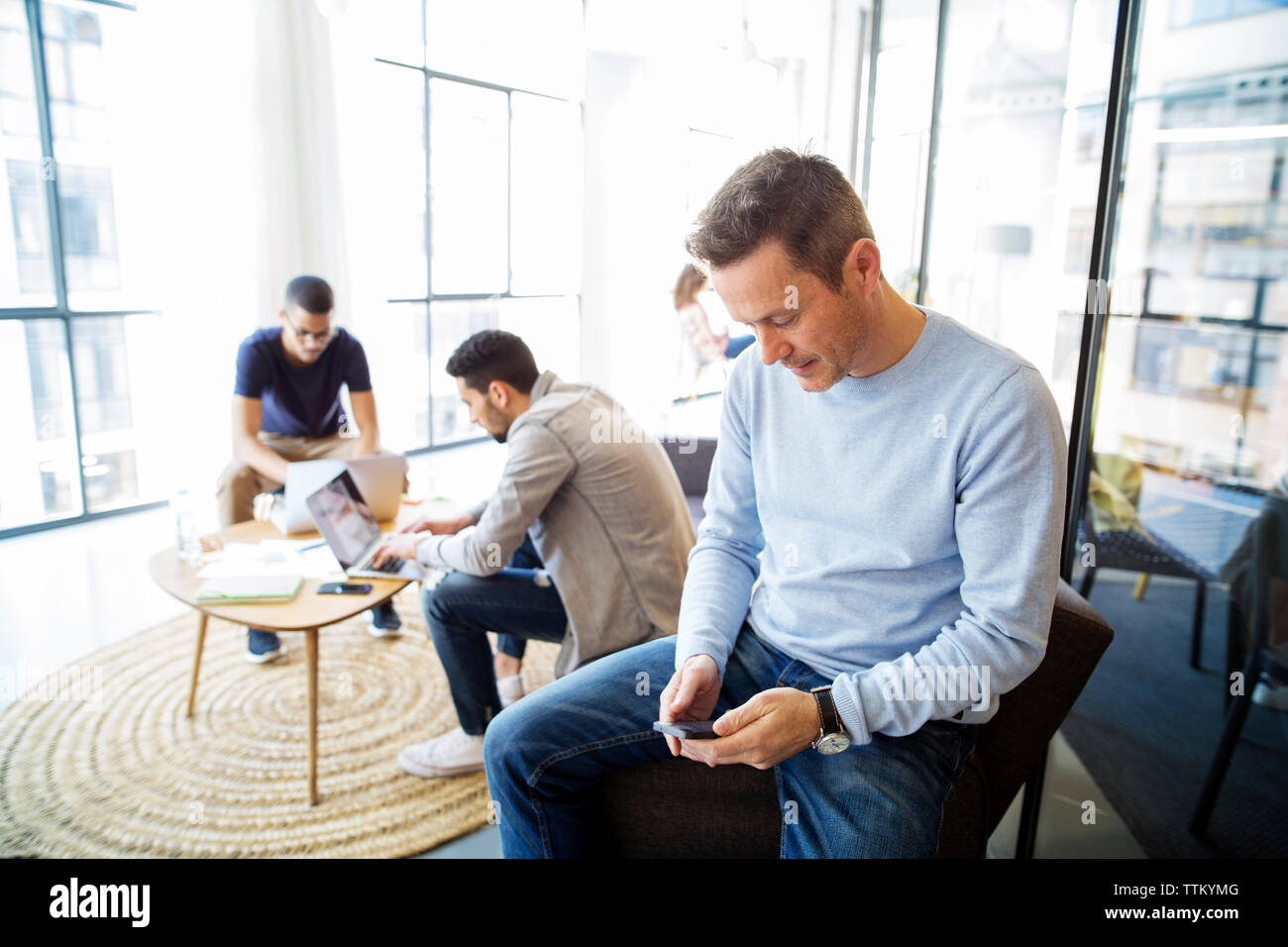 Male colleagues working in room at office Stock Photo - Alamy