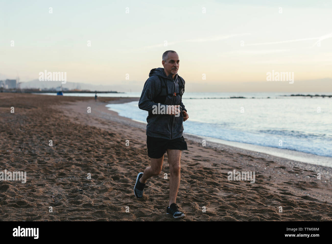 Man jogging at beach against sky during sunset Stock Photo - Alamy