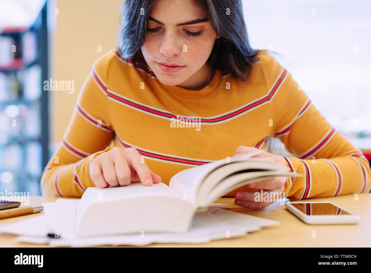 Woman reading sitting table hi-res stock photography and images - Alamy
