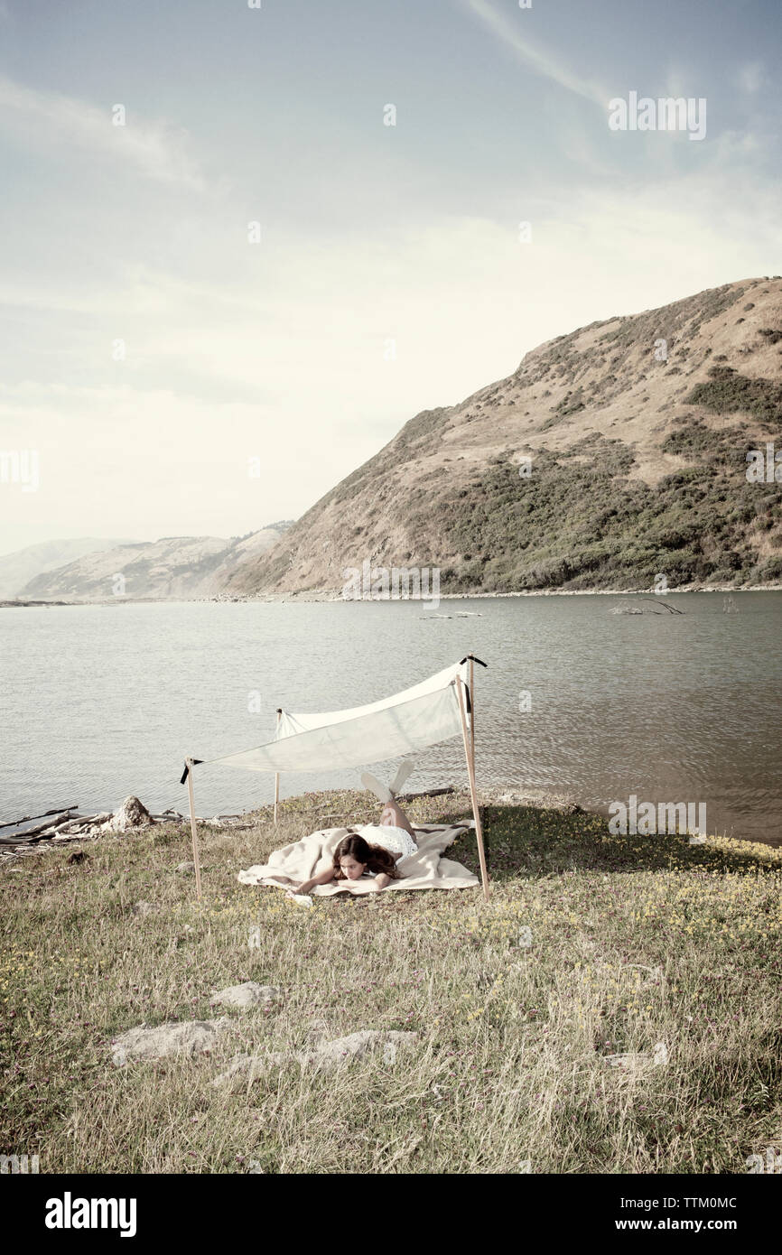 Woman relaxing under shade at seashore Stock Photo - Alamy