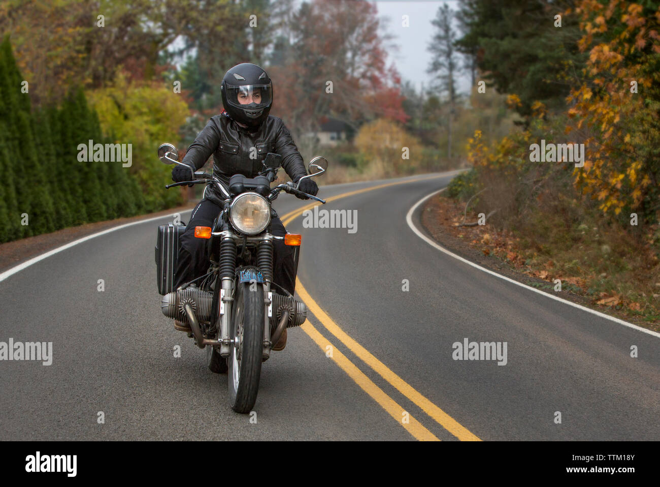 Female biker riding motorcycle on country road Stock Photo - Alamy