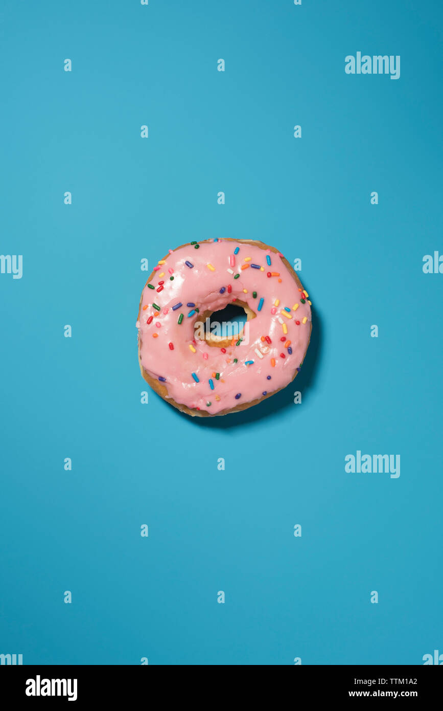 Overhead view of doughnut on blue background Stock Photo - Alamy