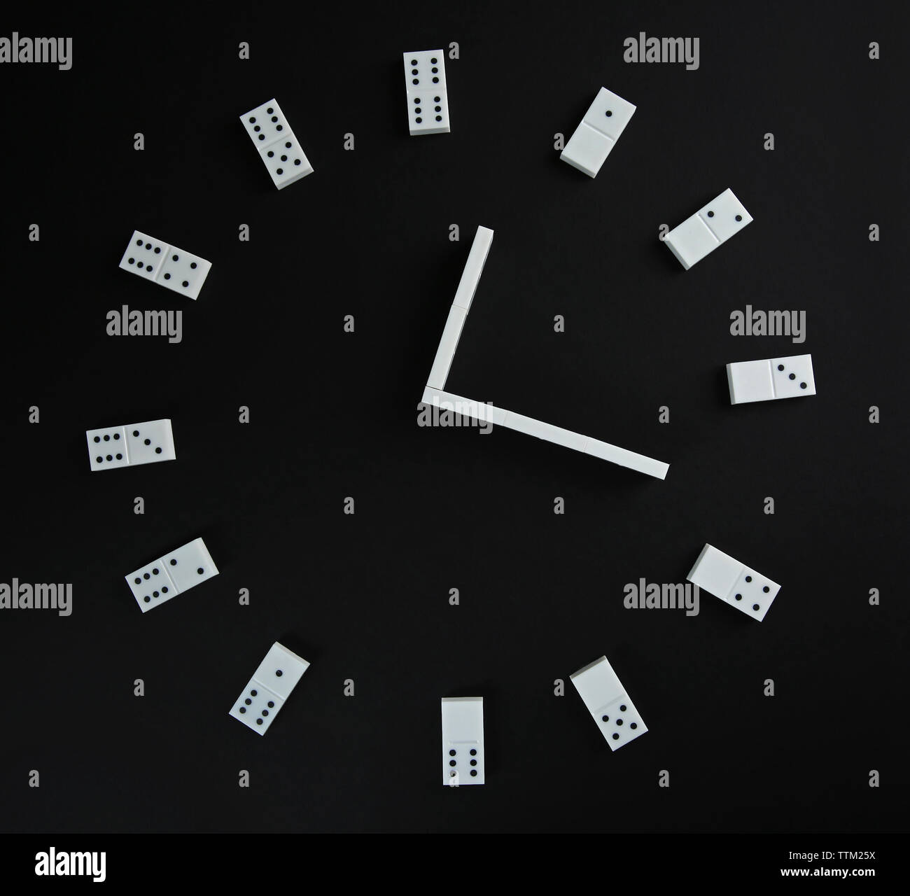 Dominoes in shape of clock on black background Stock Photo - Alamy