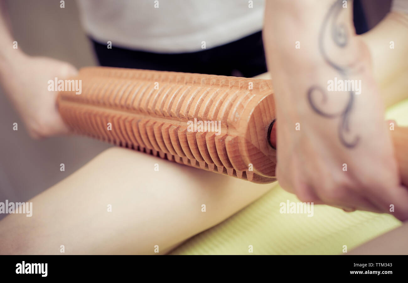 Anti-cellulite treatment. Young woman doing maderotherapy massage ...
