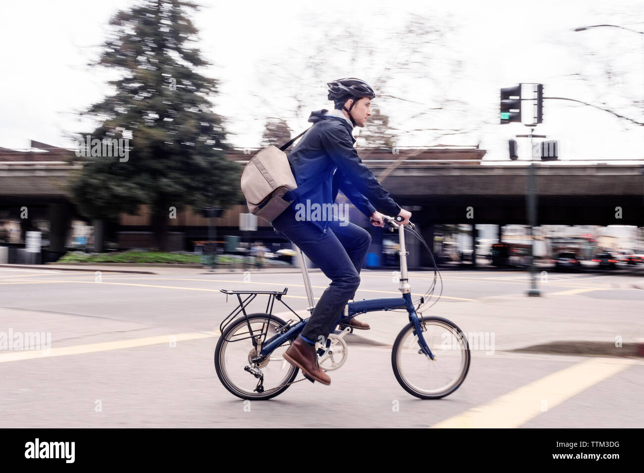 Side view of businessman riding bicycle on city street Stock Photo - Alamy