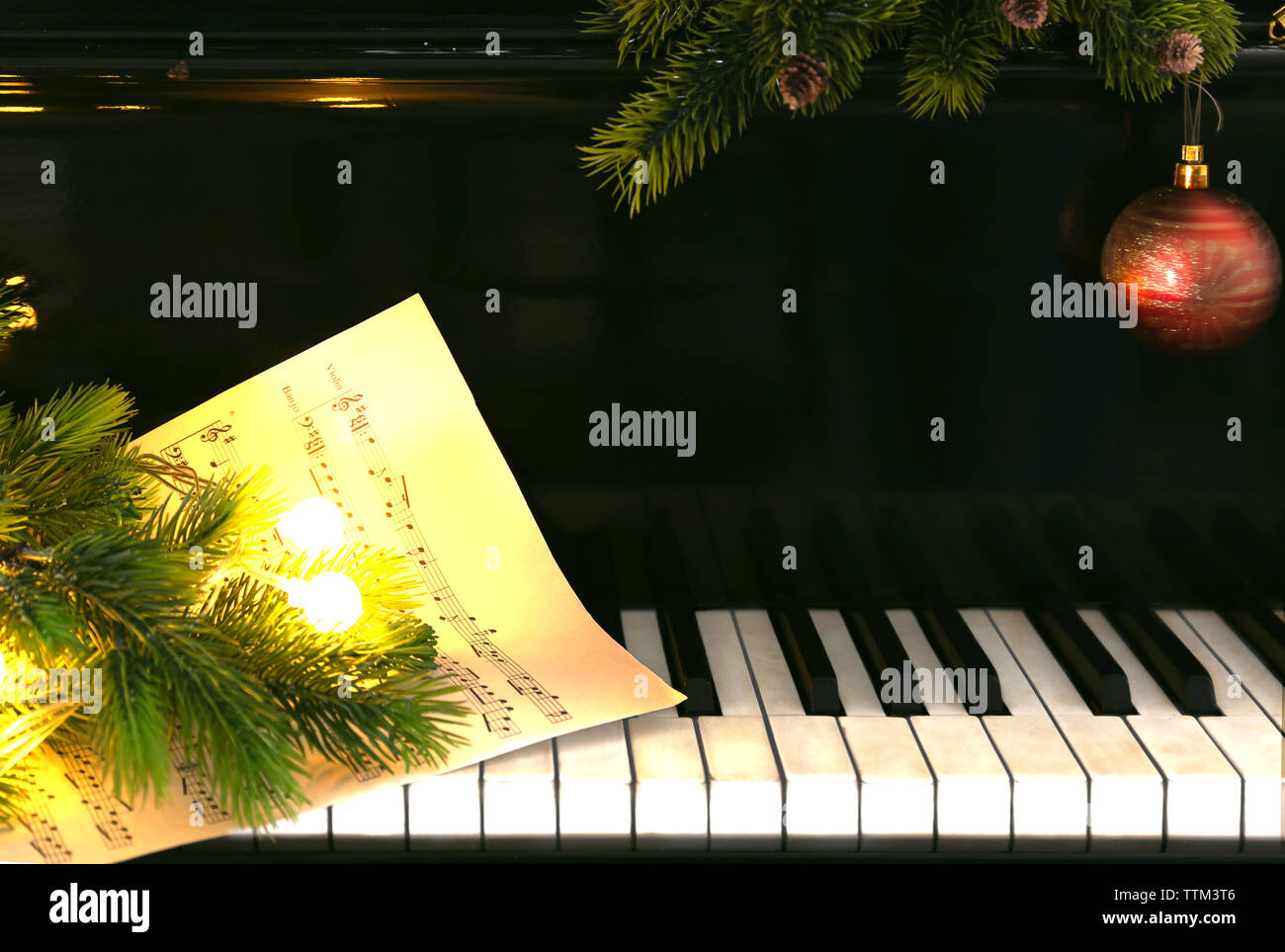 Music notes on piano keys with Christmas decoration Stock Photo - Alamy