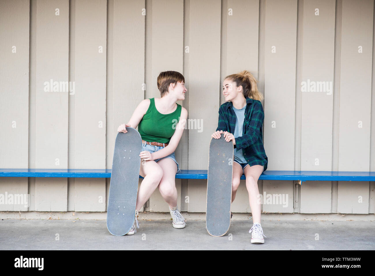 Two girls talking on bench hi-res stock photography and images - Alamy