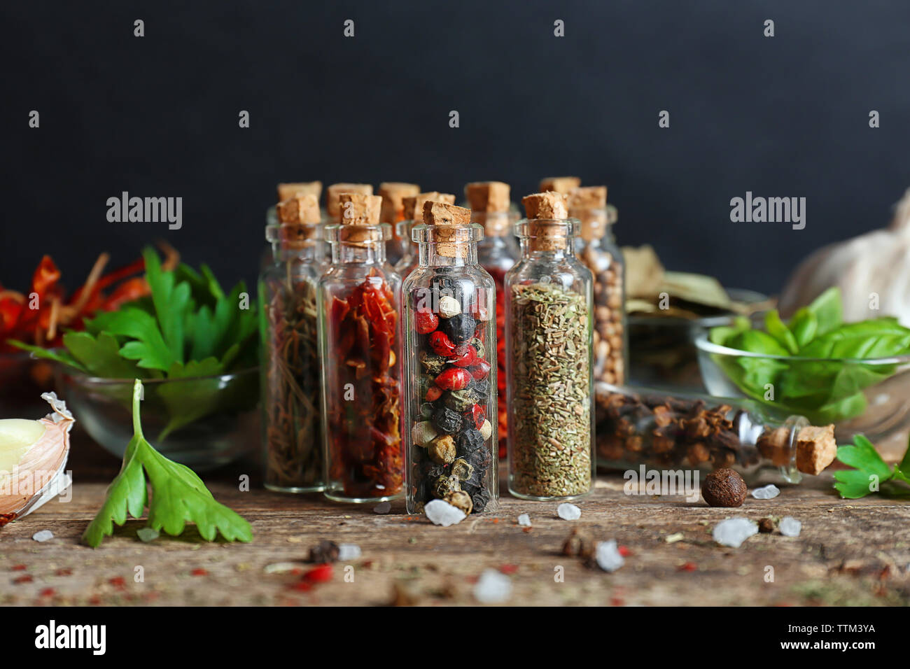 Assorted dry spices in glass bottles on dark background Stock Photo - Alamy