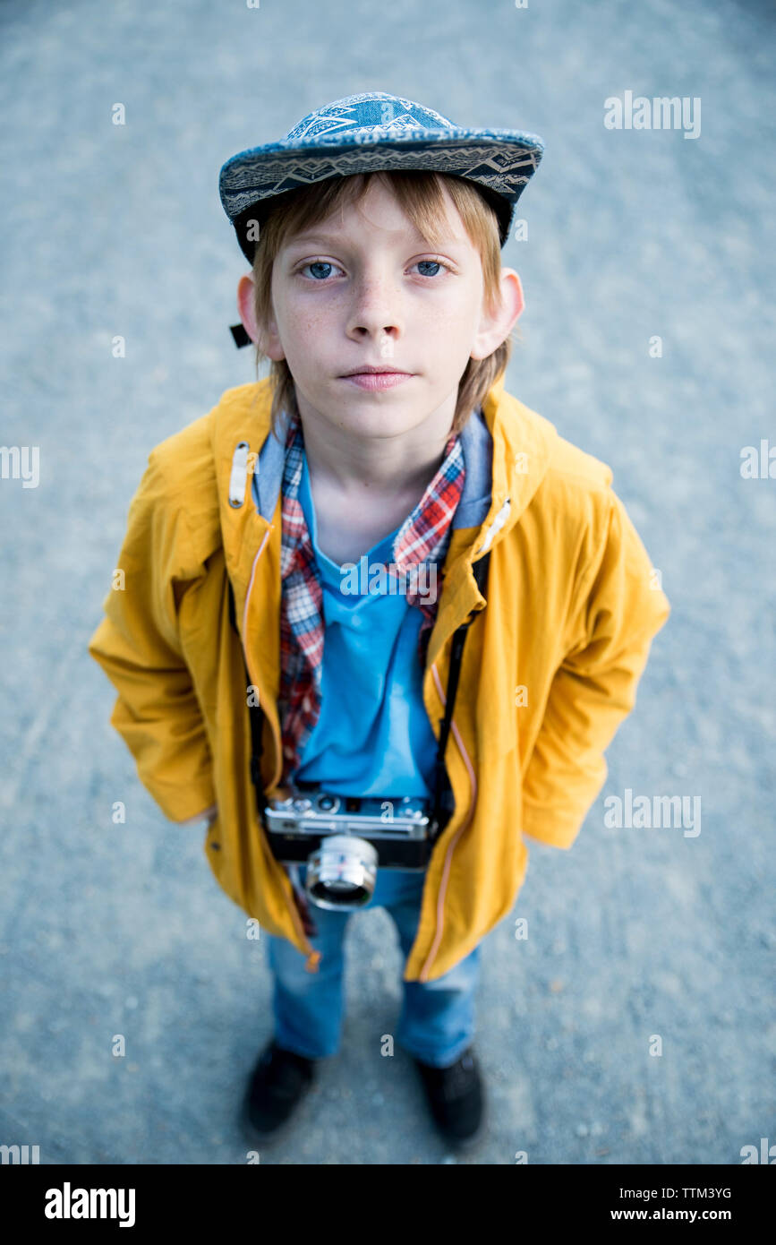 High angle portrait of boy with camera standing on road Stock Photo - Alamy