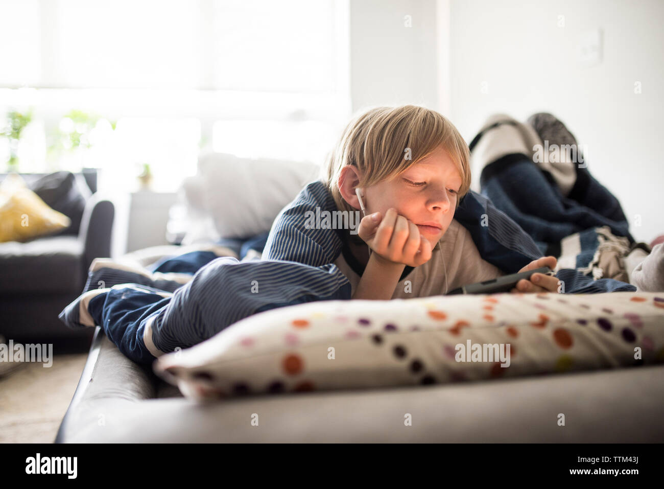 Boy using mobile phone while lying on bed at home Stock Photo - Alamy